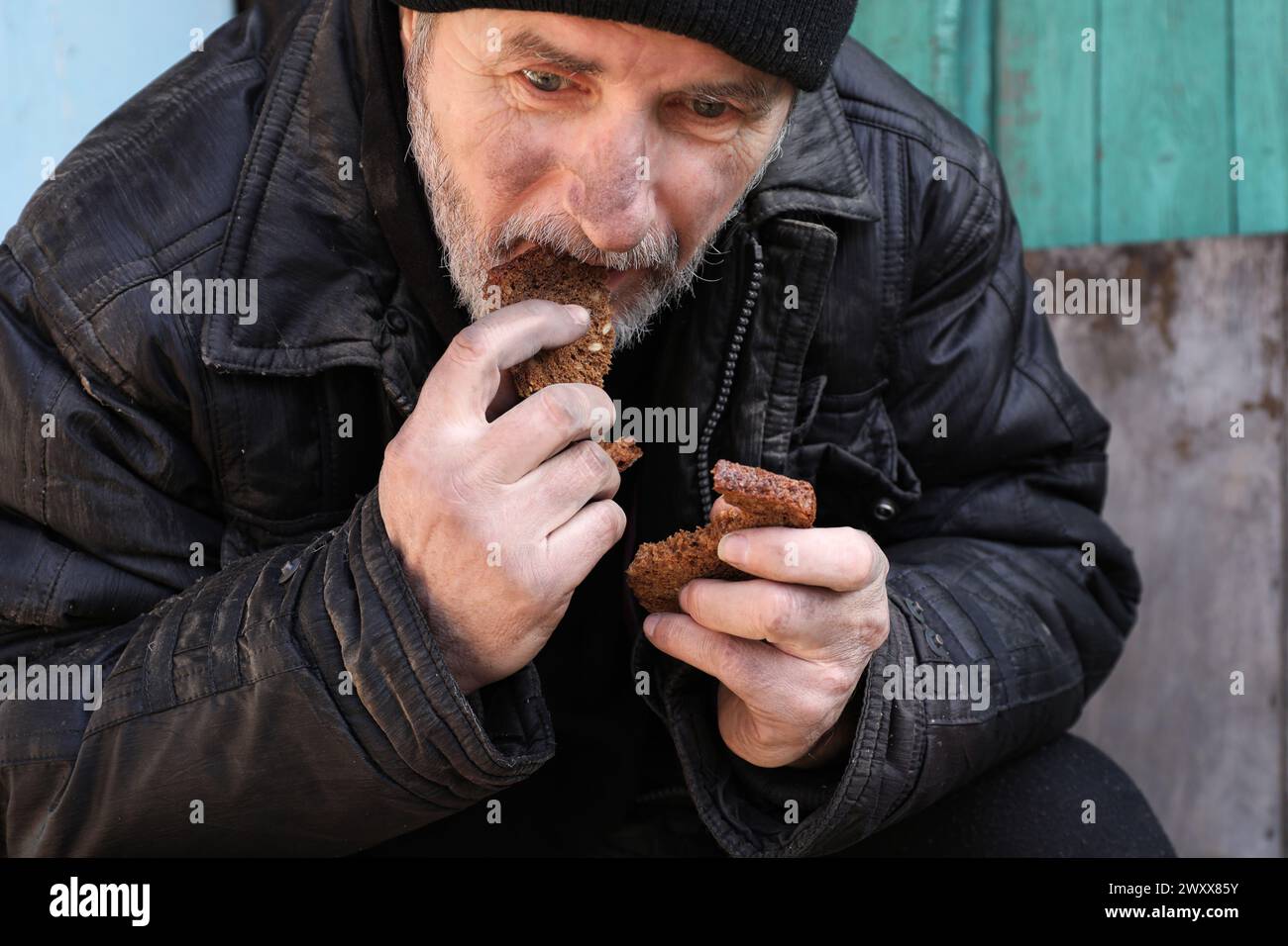 Poor homeless man holding piece of bread outdoors Stock Photo - Alamy
