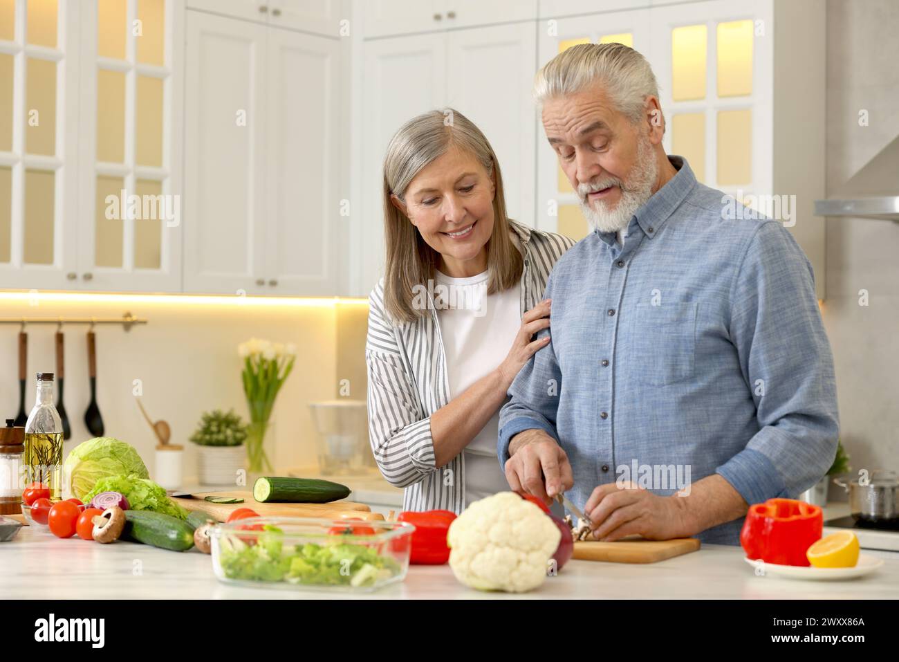 Happy senior couple cooking together in kitchen Stock Photo - Alamy