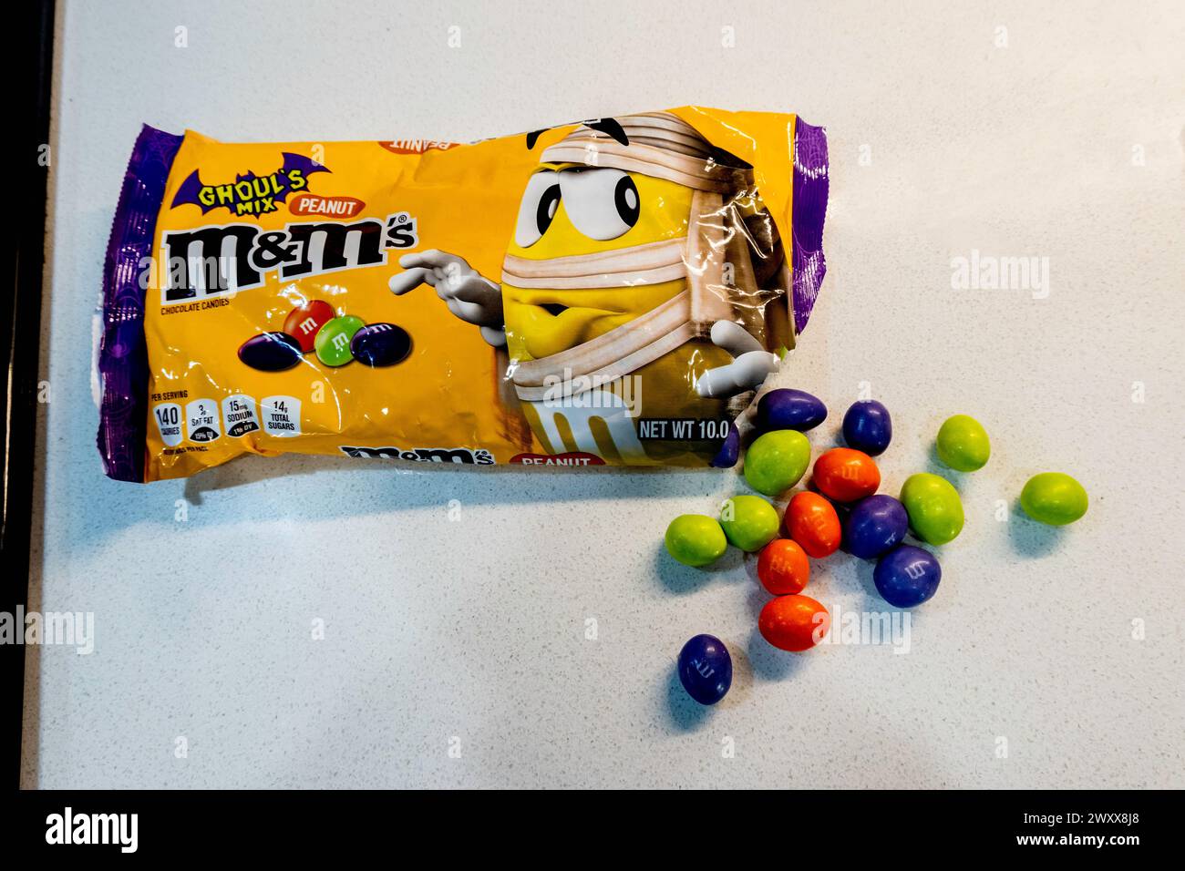 Package of peanut M&M’s made for Halloween with spilled candy pieces ...