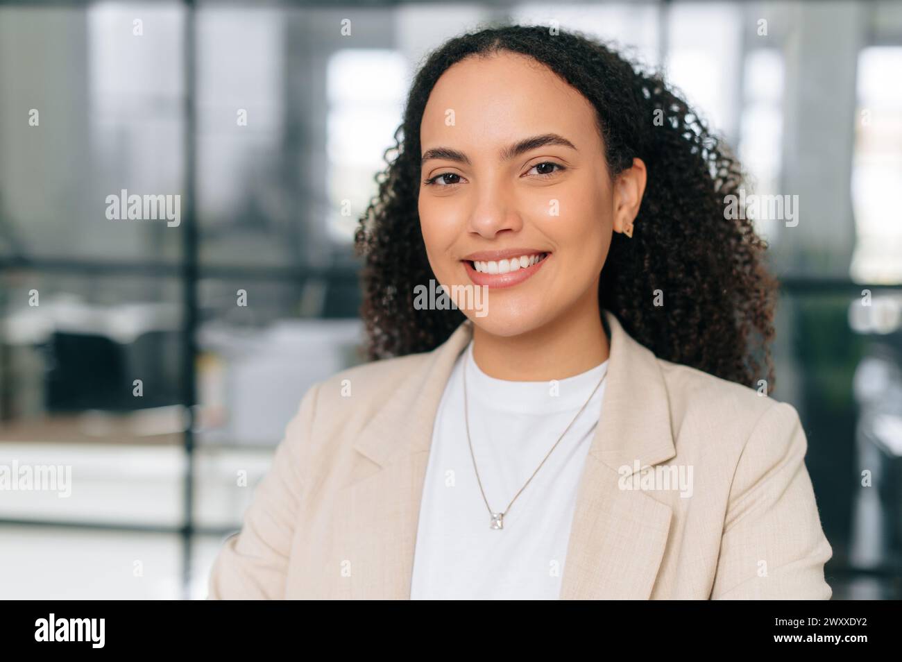 Close-up photo of a successful beautiful curly haired brazilian or ...