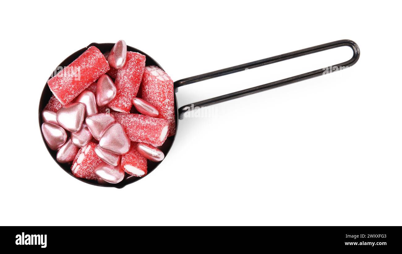 Yummy candies in measuring cup isolated on white, top view Stock Photo ...