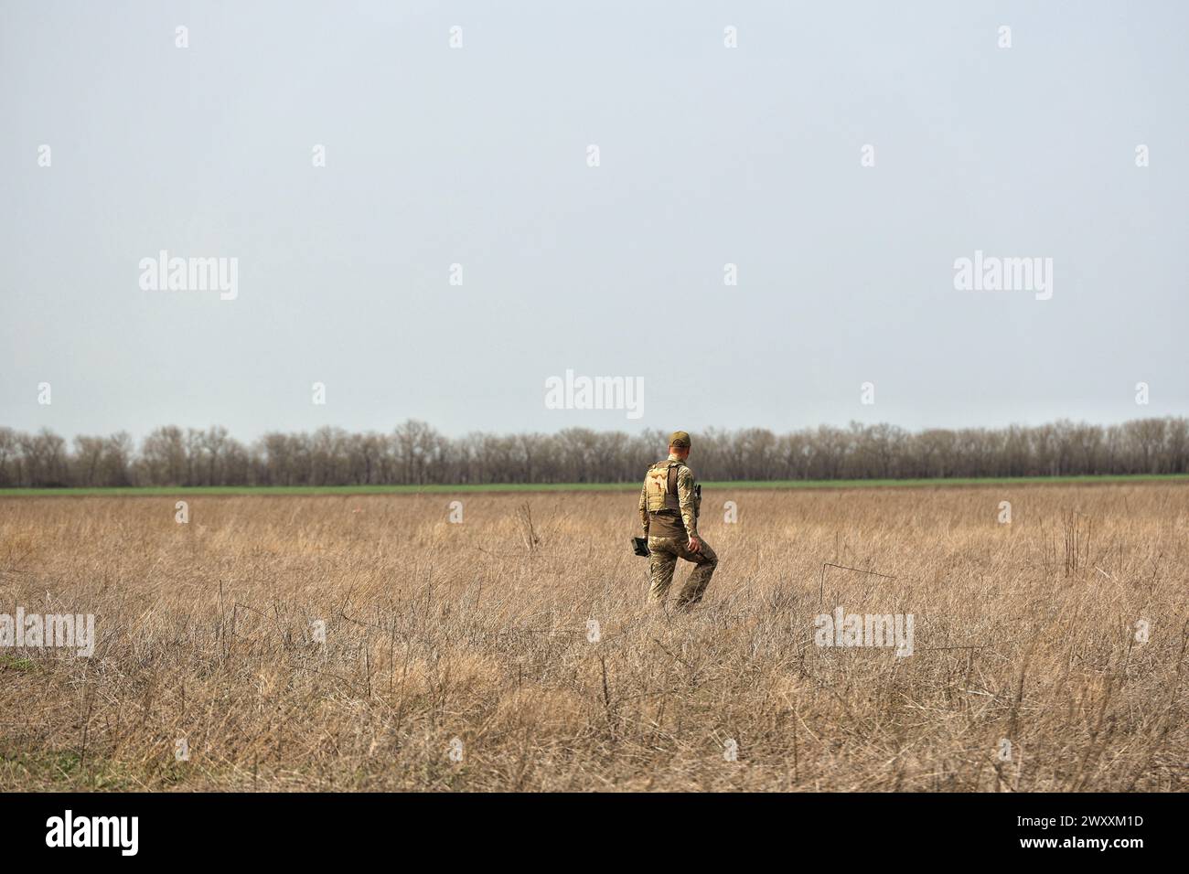 MYKOLAIV REGION, UKRAINE - APRIL 02, 2024 - A serviceman with a metal ...