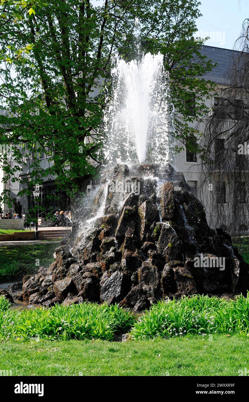 Museum park, A fountain bubbles amidst boulders under a clear sky ...