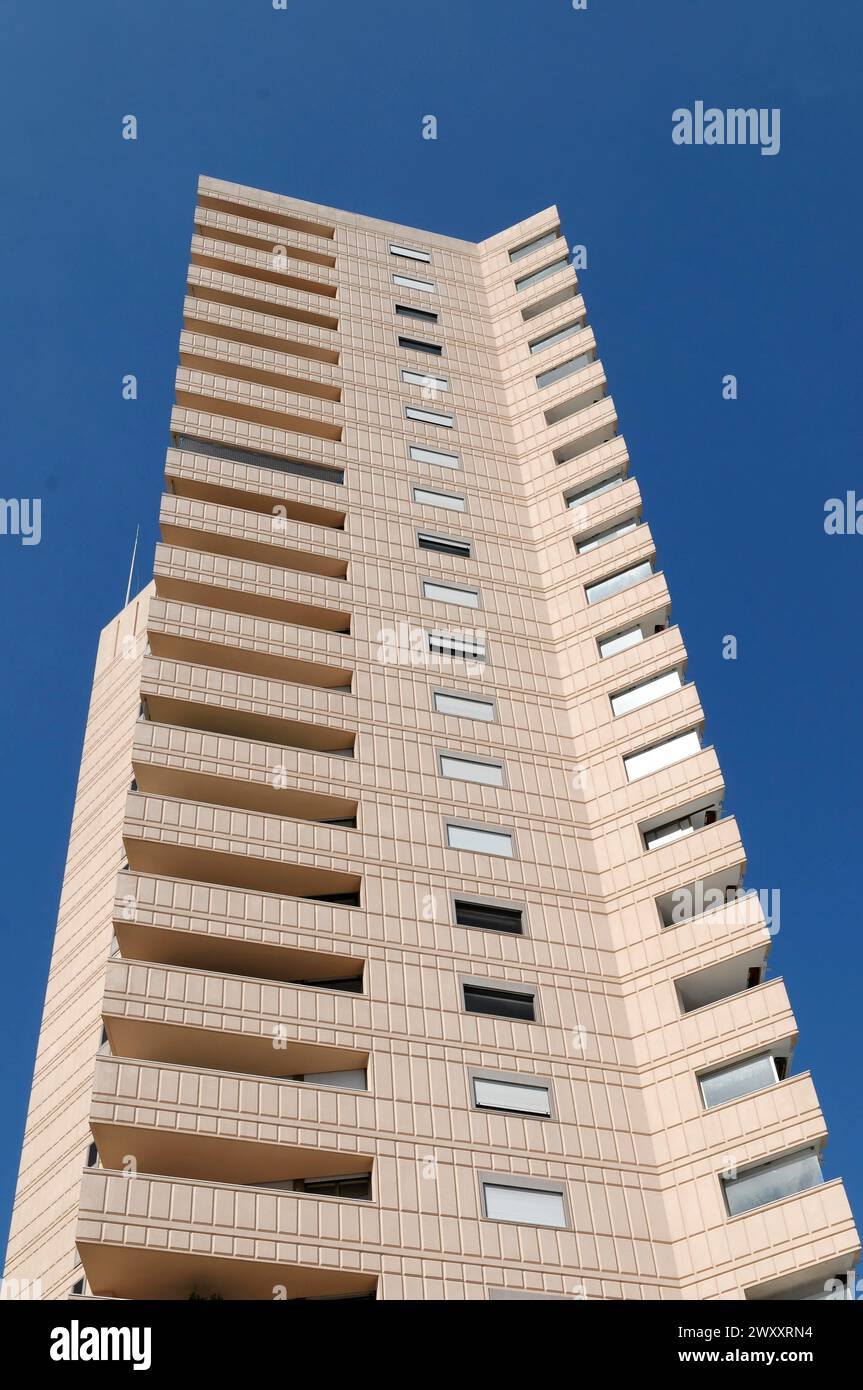 A modern skyscraper with a honeycomb structure rises into the blue sky ...
