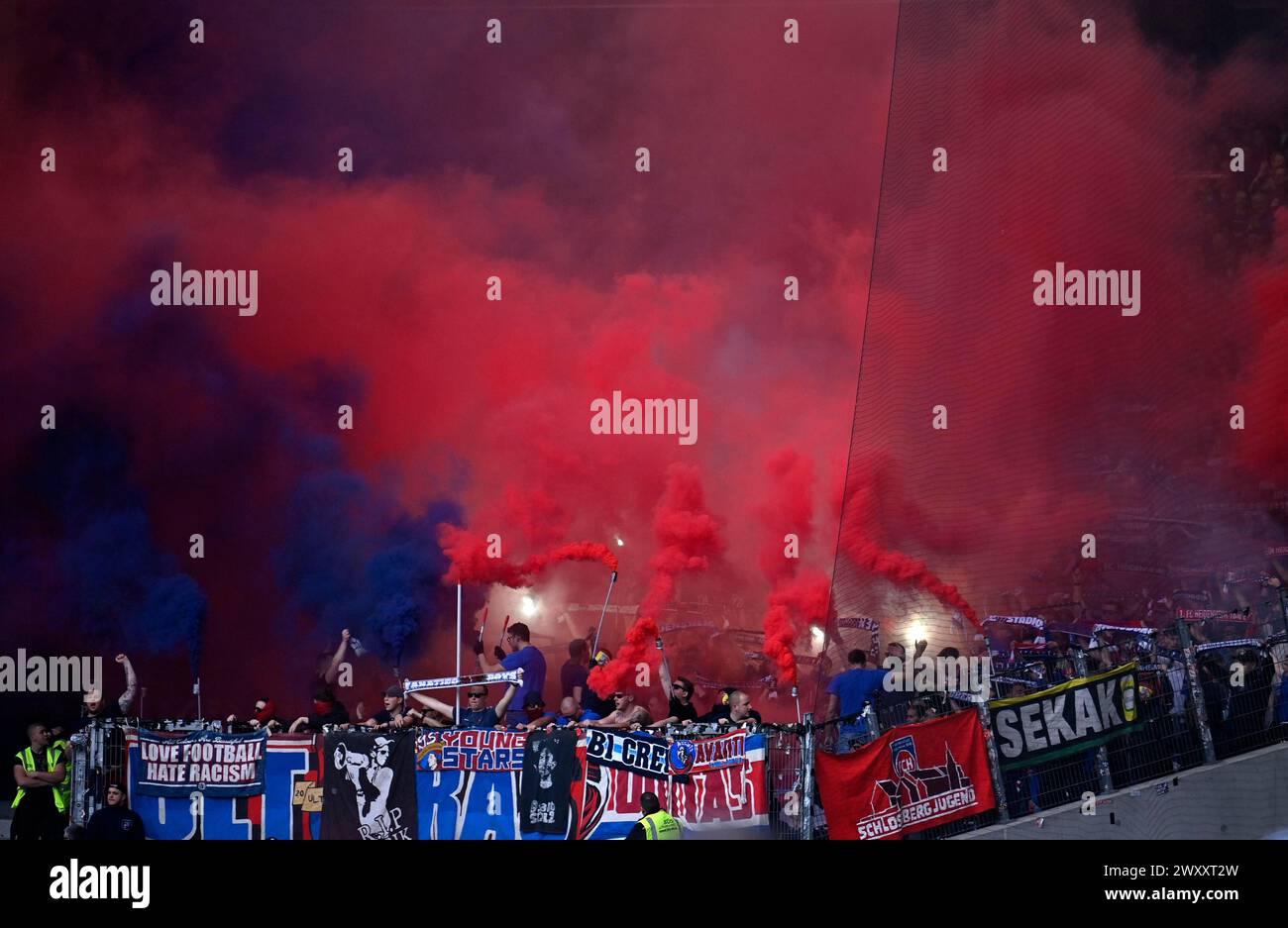 Fanblock 1. FC Heidenheim 1846, Bengalos in red and blue, smoke ...
