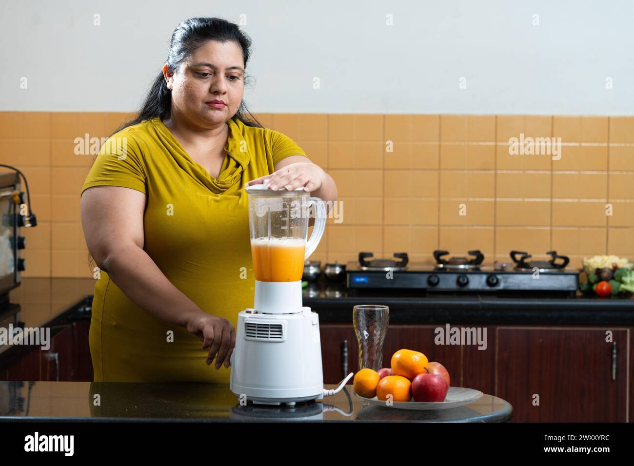Overweight fat indian woman using blender or Juicer Mixer Grinder for ...