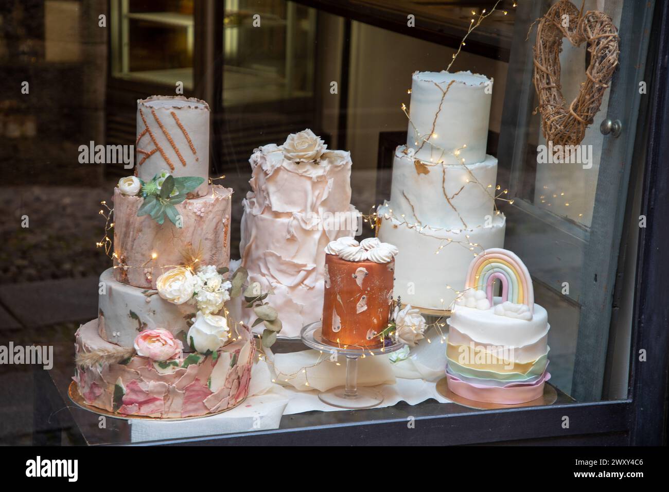 Whimsical cake display in a bakery display case with intricate icing ...