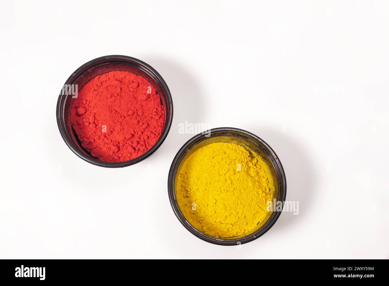 Red and yellow Holi powder colors in plastic box on white background ...