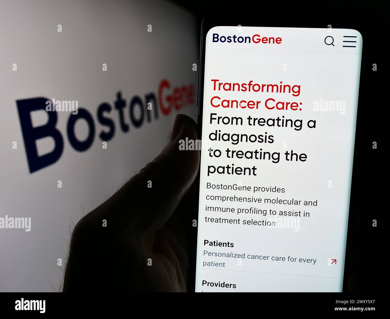 Person holding cellphone with webpage of US biotechnology company ...