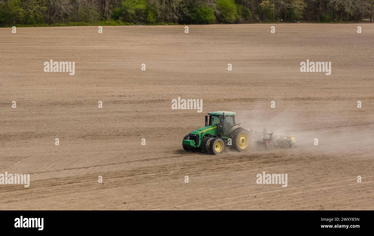 A tractor plowing fields, kicking up dust and grass in Gibson, North ...