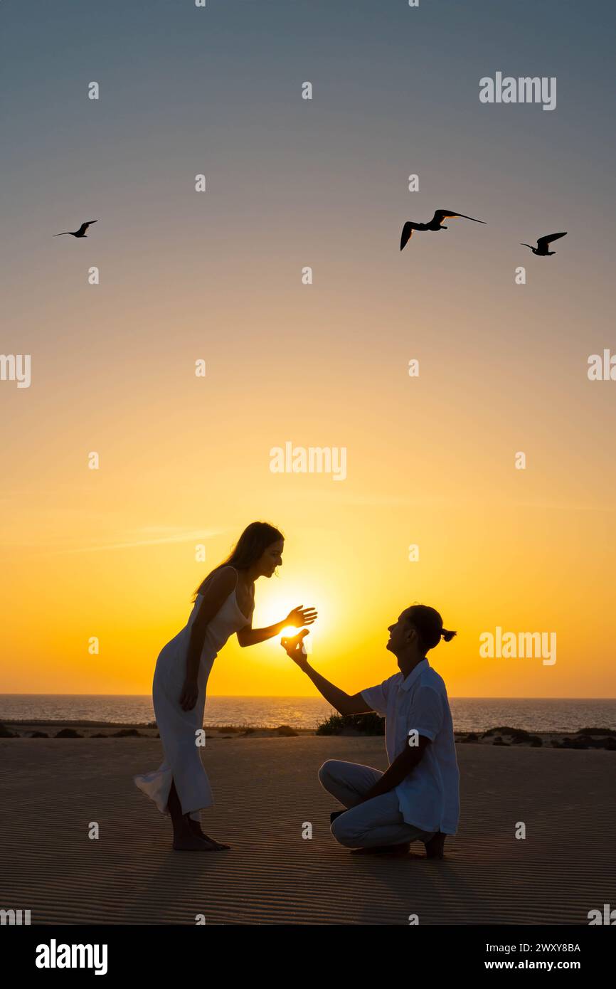 Romantic engagement proposal at the tranquil sunset beach with a ...