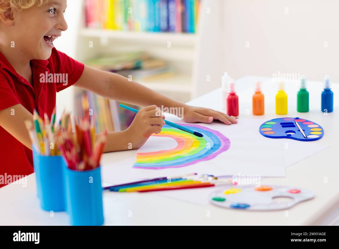 Kids paint. Child painting in white sunny study room. Little boy ...