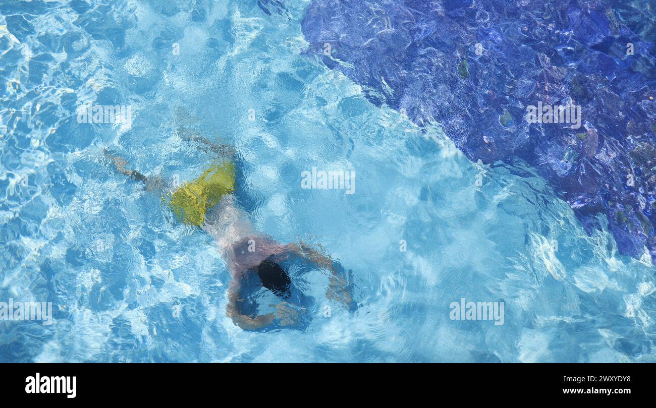 Young man lying on bottom of swimming pool top view Stock Photo - Alamy