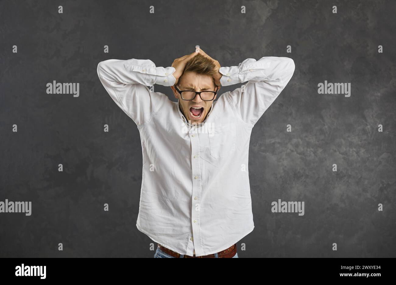 Emotional angry man in panic hysterics screams in pain and frustration ...