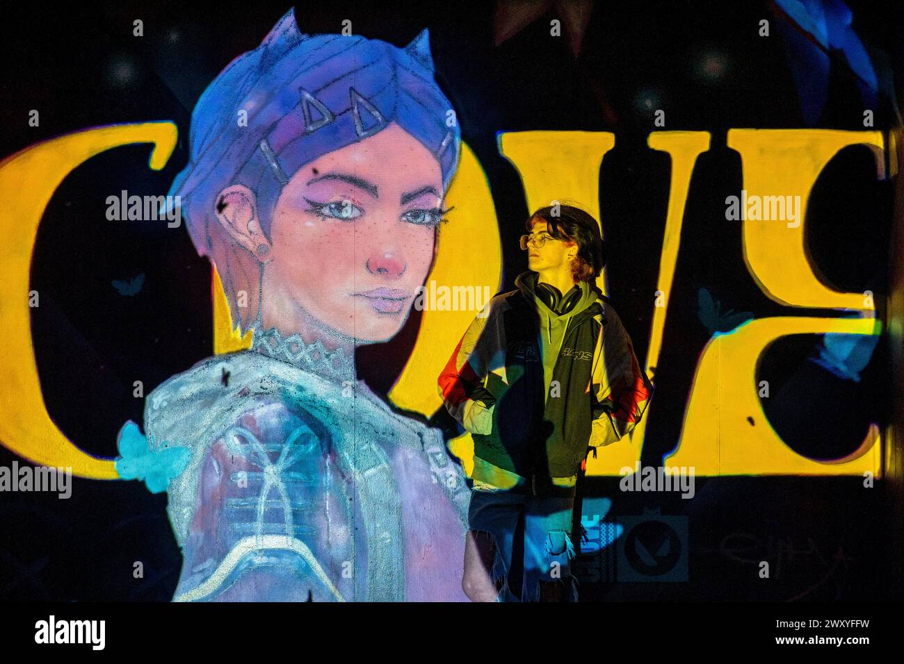 Corey Gorman, from Edinburgh, stands alongside a multi-panel animated ...