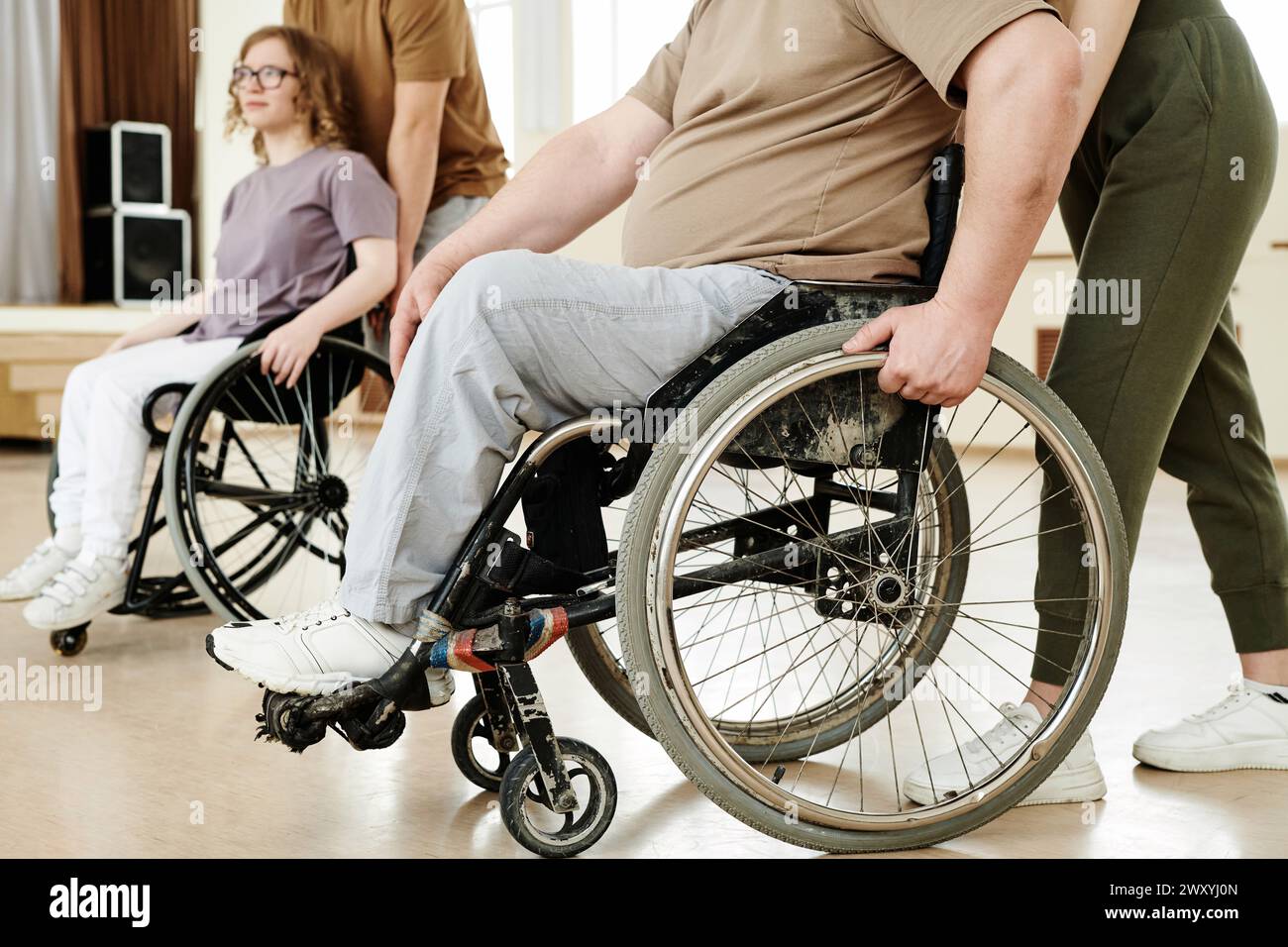 Crop shot of two people with disabilities and their partners practicing dance with wheelchairs ...