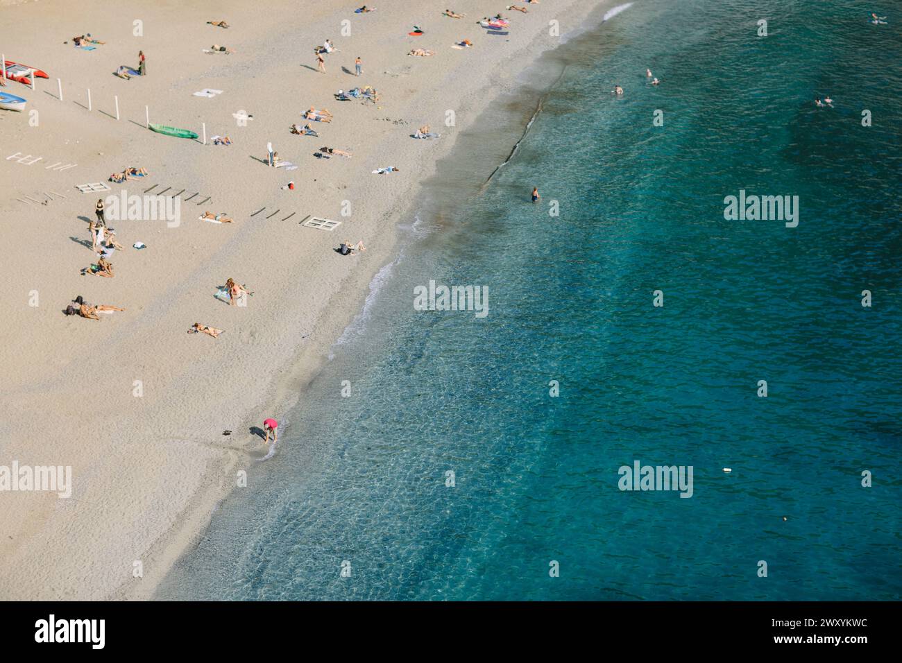 Aerial view of a sandy beach with people sunbathing and swimming in ...