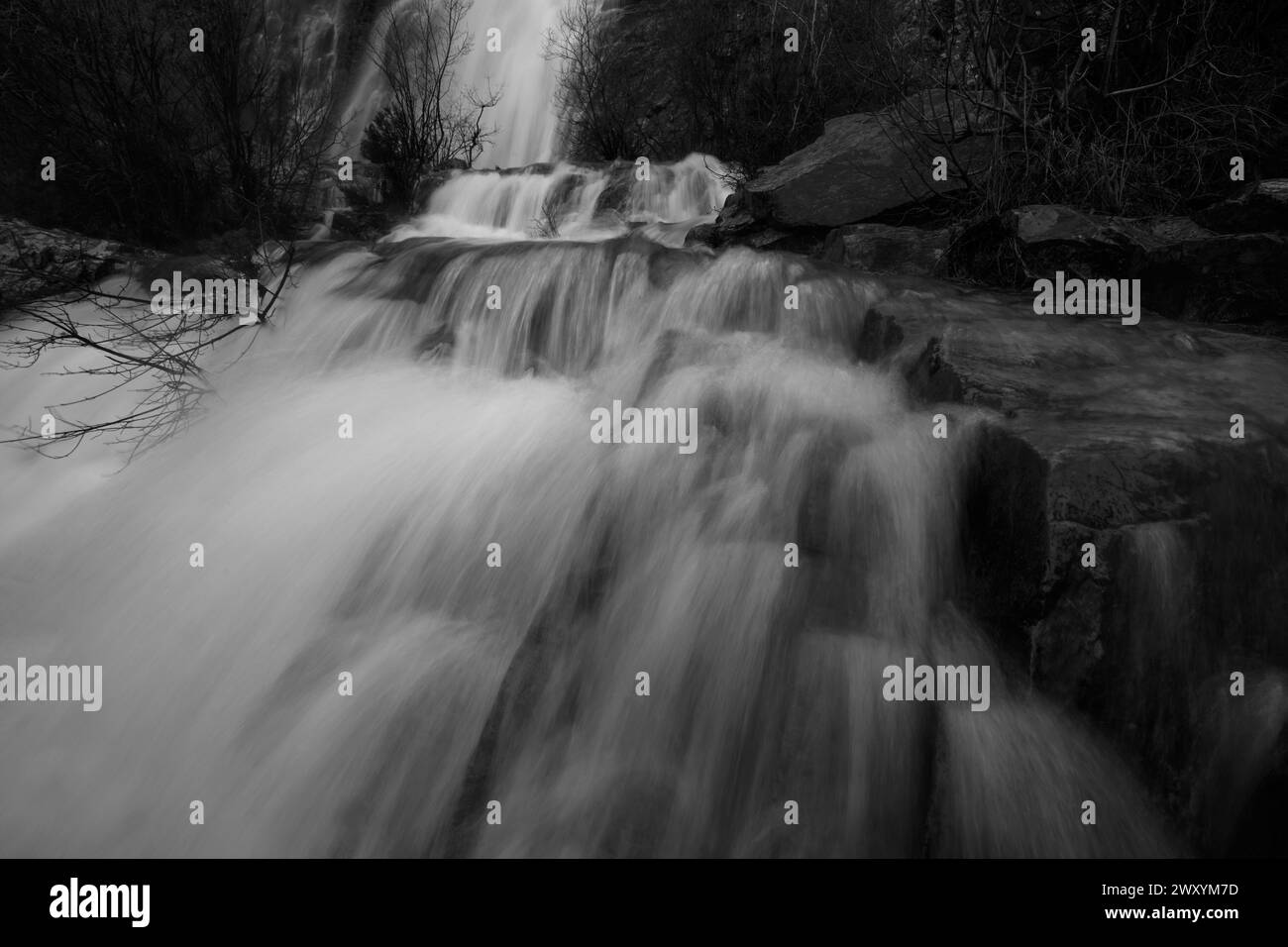 Smooth textures of the Rio Mundo Waterfall are accentuated in greyscale ...