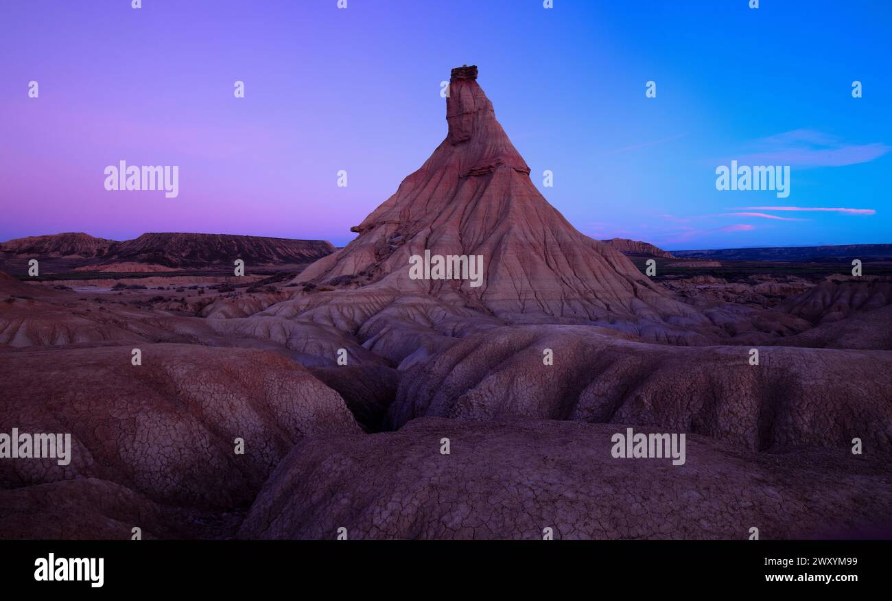 The iconic outline of a badlands rock formation is silhouetted against ...
