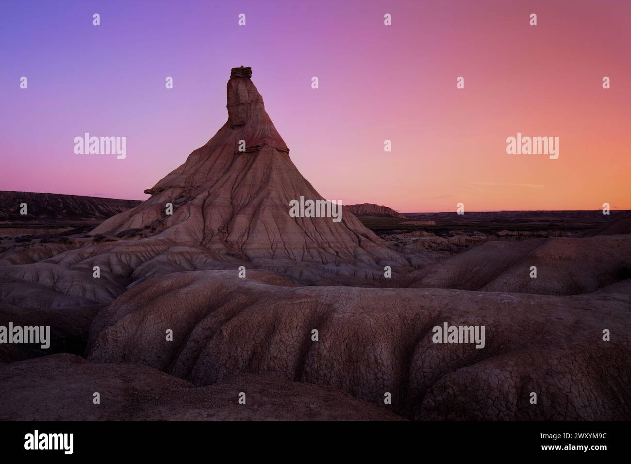 Captivating twilight colors paint the sky above a striking badlands ...