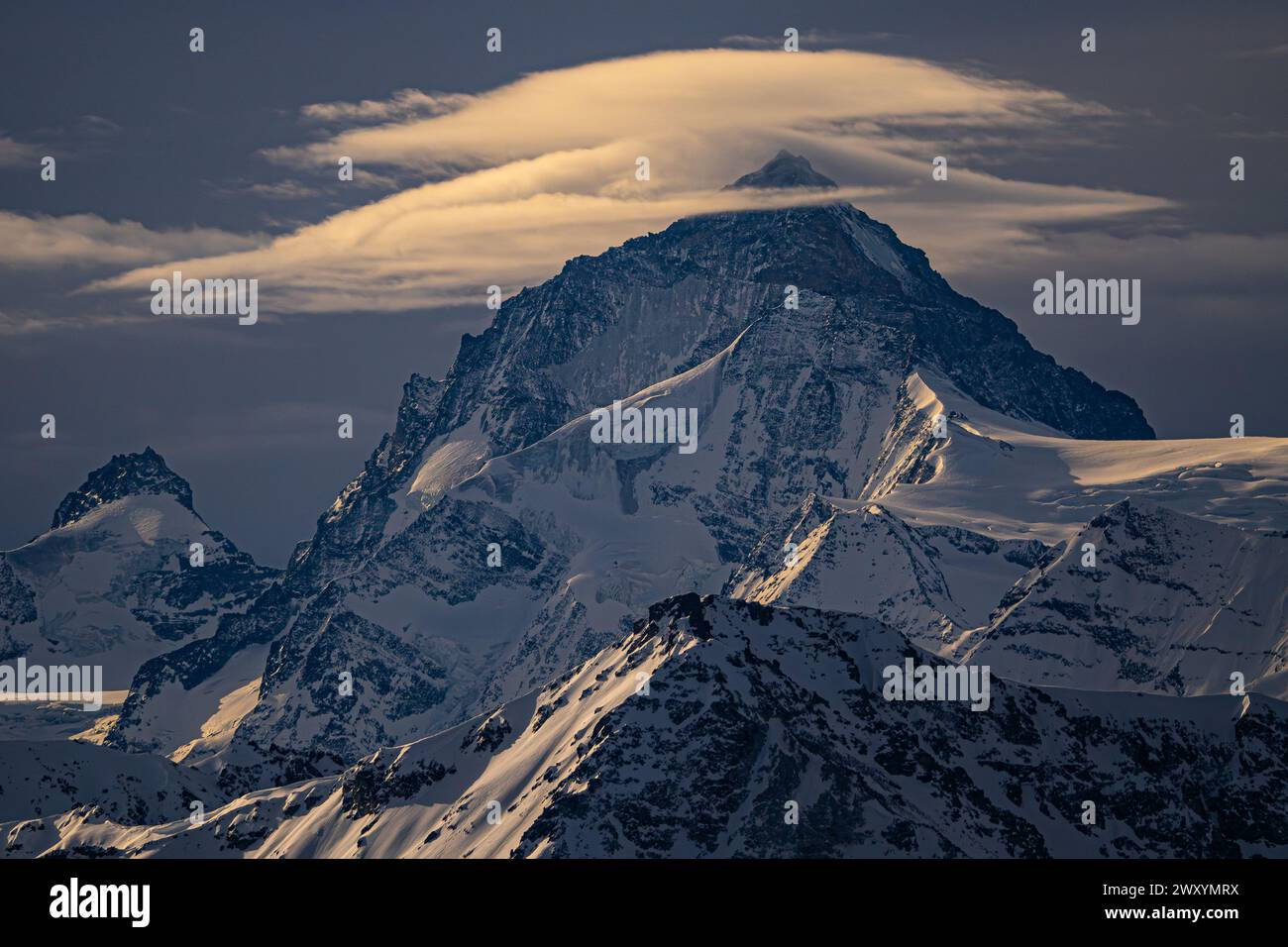 A stunning mountain peak is crowned by a lenticular cloud, with the ...