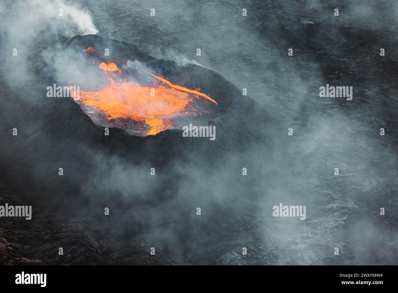 Aerial view of a vibrant molten lava flow amidst the steam and ash in ...