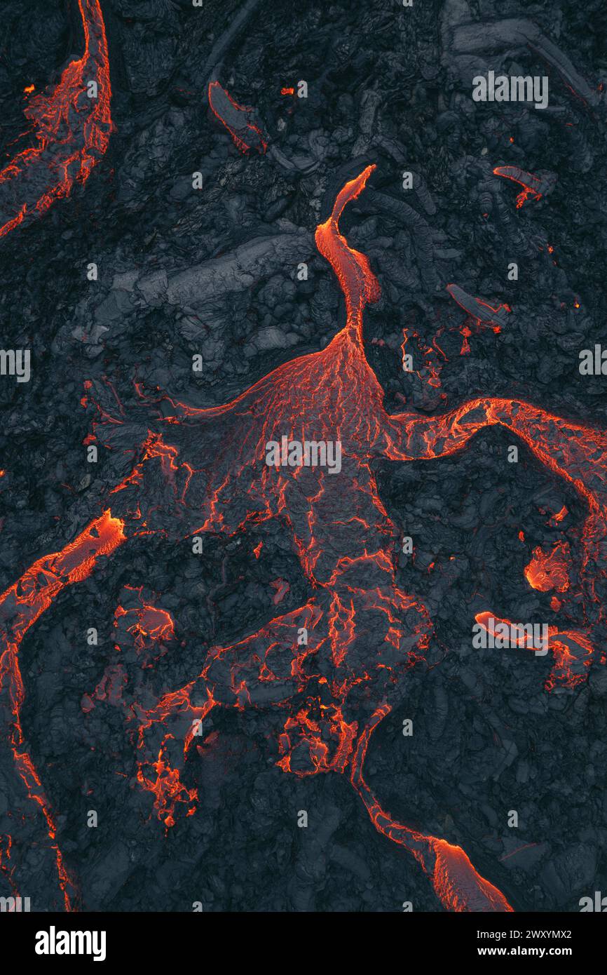 Aerial view of glowing lava veins weaving through dark, hardened ...