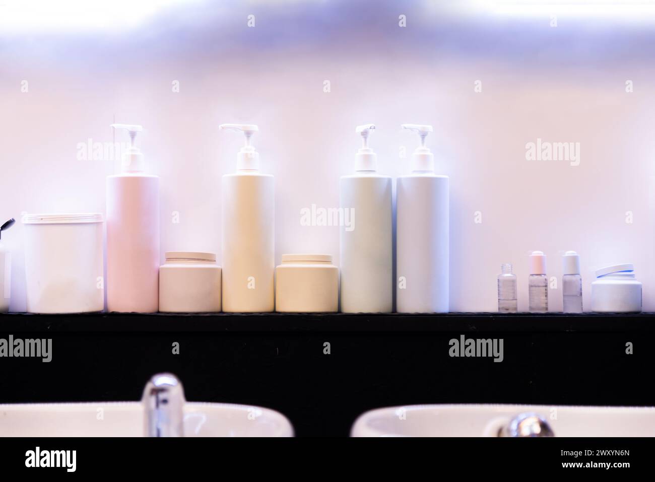 A variety of hair care products neatly lined up on a salon shelf, ready ...