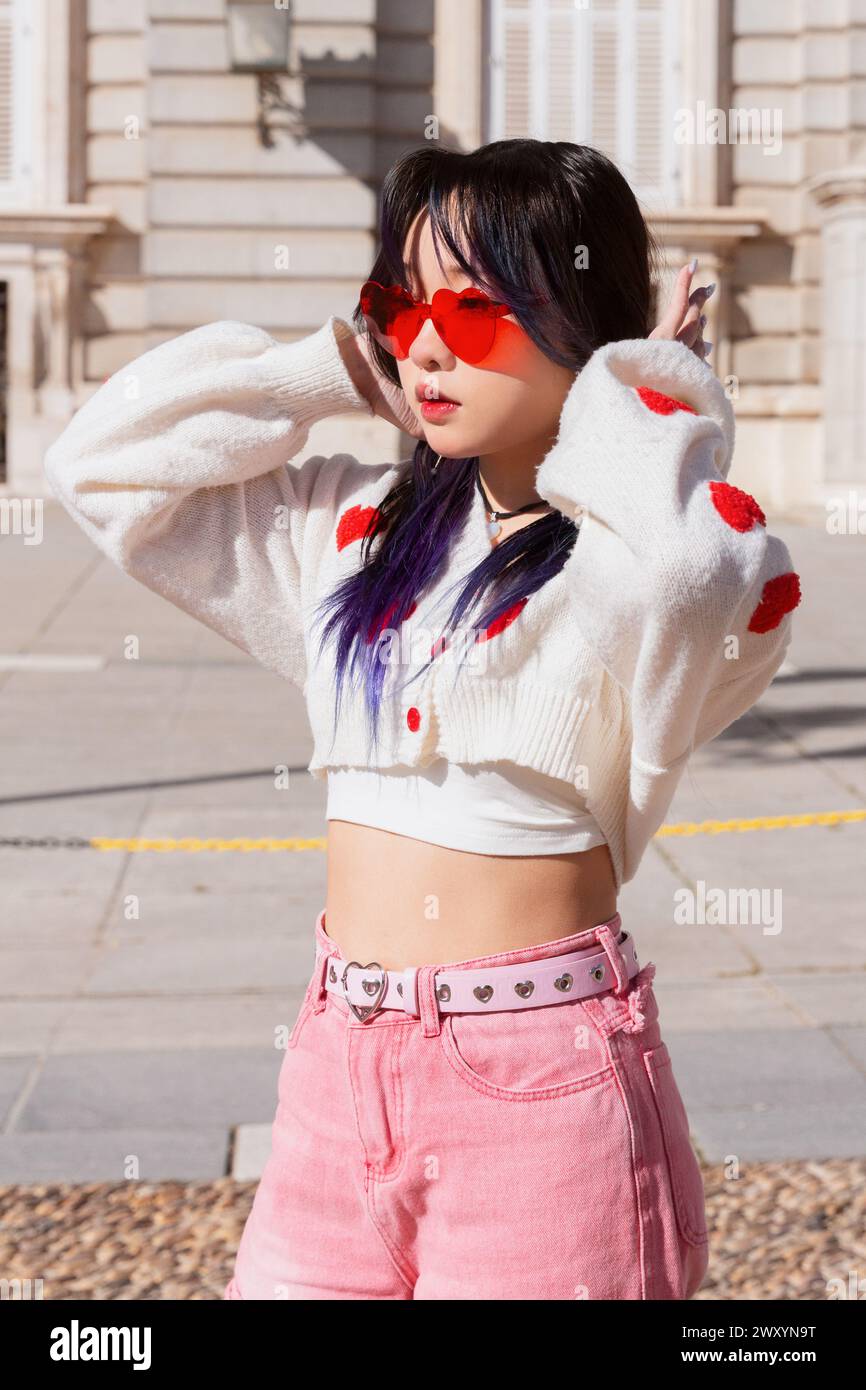A stylish young chinese girl wears heart-shaped sunglasses and a ...