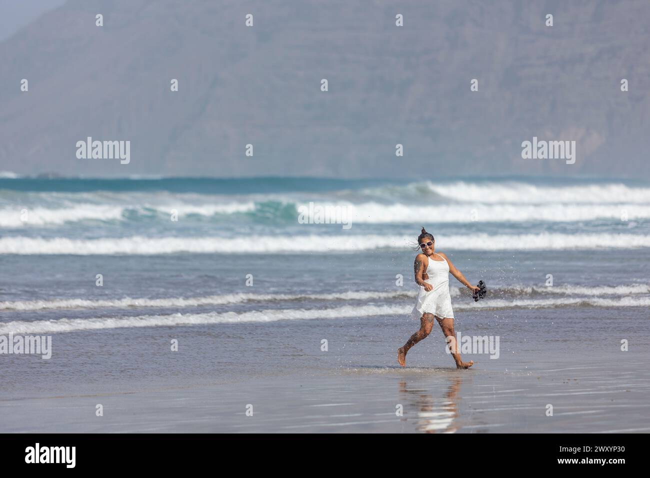 Female taking a solo walk by the sea, reflecting relaxation during a ...