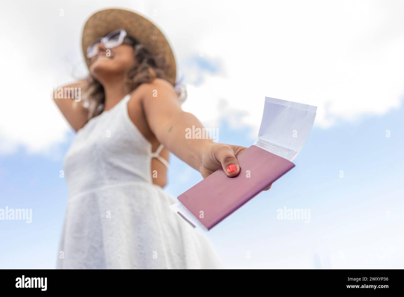 Back view of an woman holding a boarding pass, looking away and ready ...