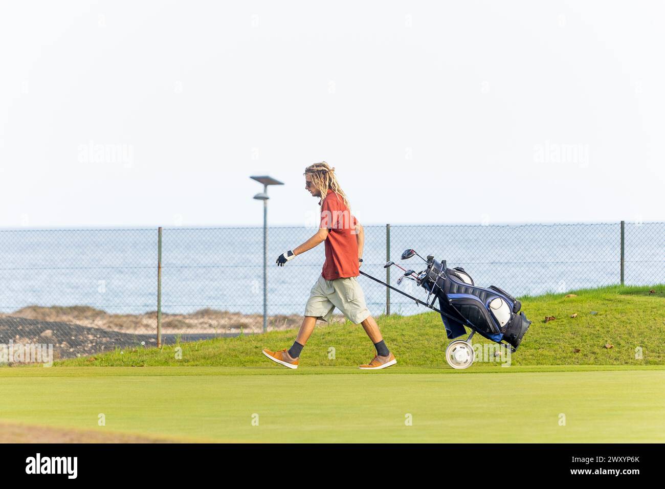 Side view of a unique golfer sporting dreadlocks and casual attire ...