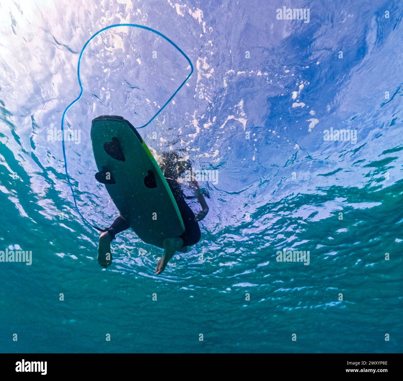 From below underwater shot capturing a surfer's duck dive beneath the ...