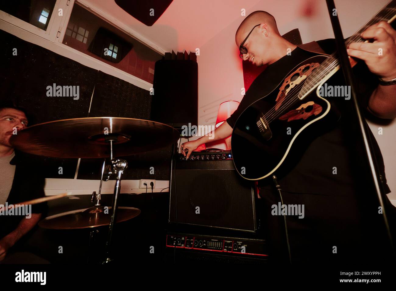 From below male drummer and guitarist intensely focus during a music ...