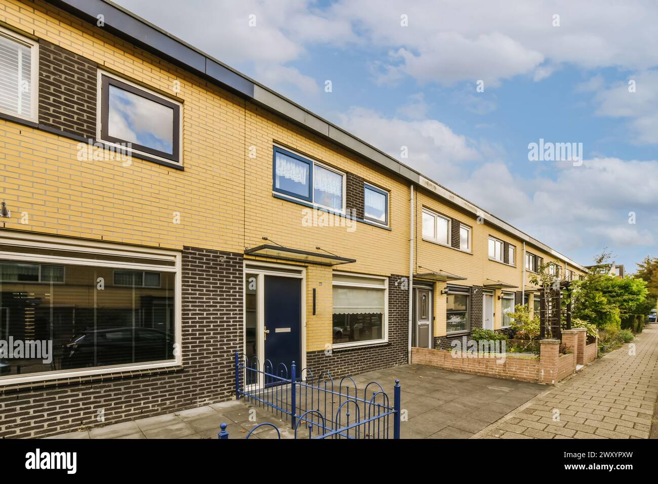 Suburban row houses with yellow brick facades and blue sky. Perfect for ...