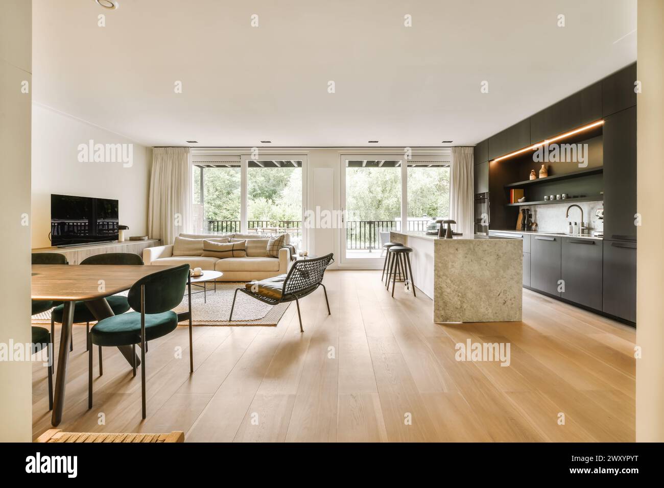 A chic and spacious living area seamlessly connects to a modern kitchen ...