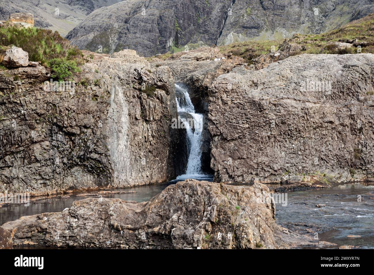 Fairy Pools waterfall cascades into a tranquil pool surrounded by ...