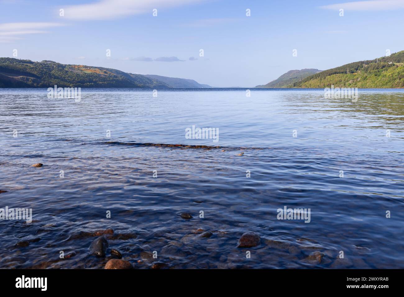 A serene view of Loch Ness under a clear sky, showcasing its vast ...