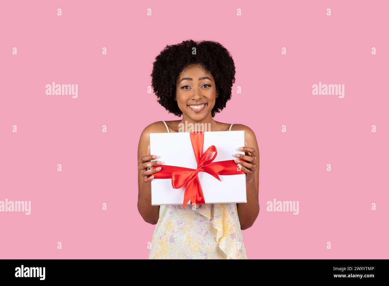 Woman presenting a white gift box with a smile Stock Photo - Alamy