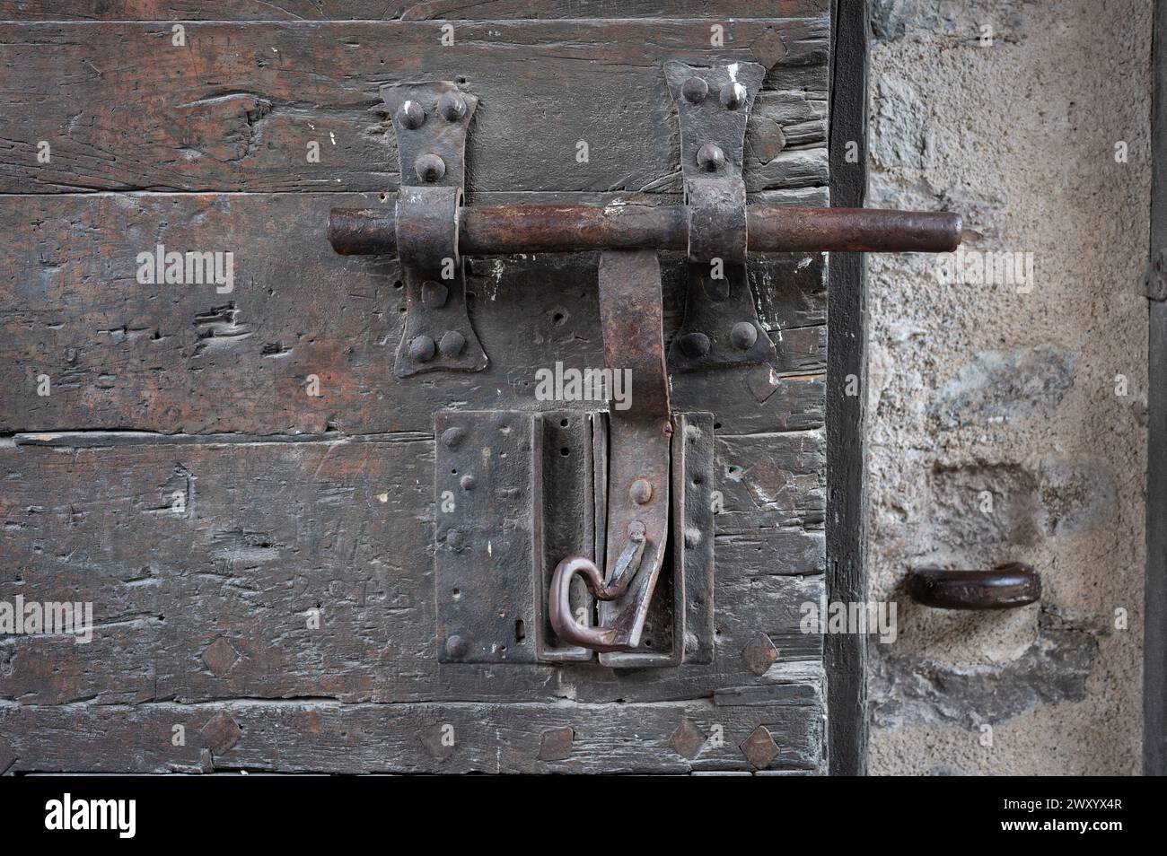 Detail of the old bolt or latch made in the forge of an old medieval ...