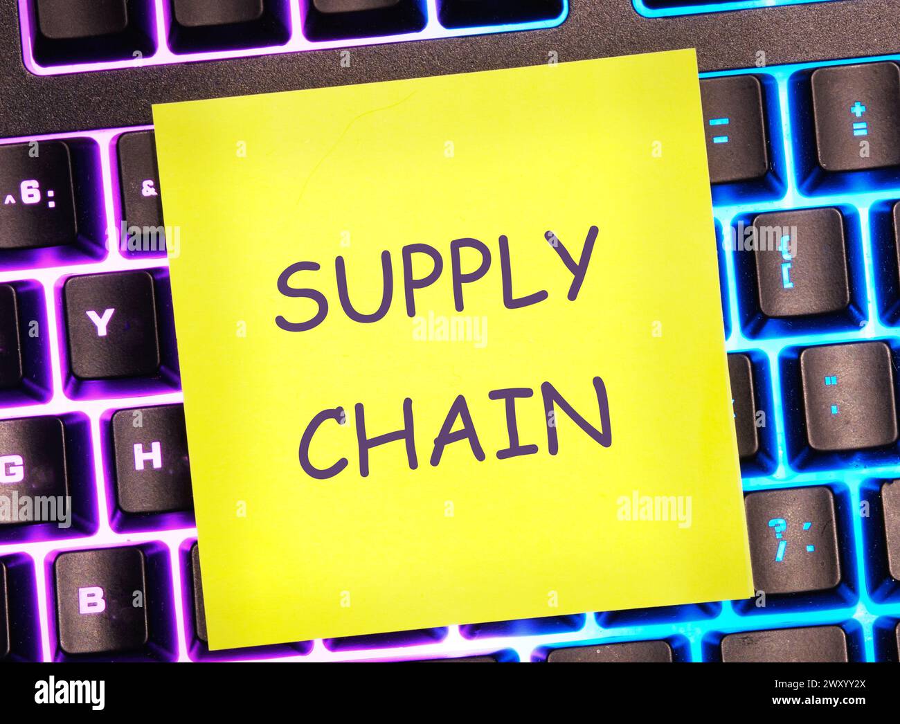 The words Supply Chain written on a yellow sticker on a colored backlit ...