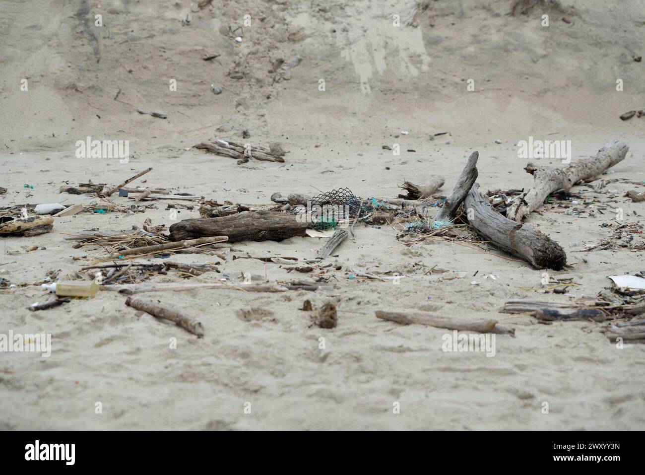 Plastic waste and various objects on the sand by the beach. Trash on ...