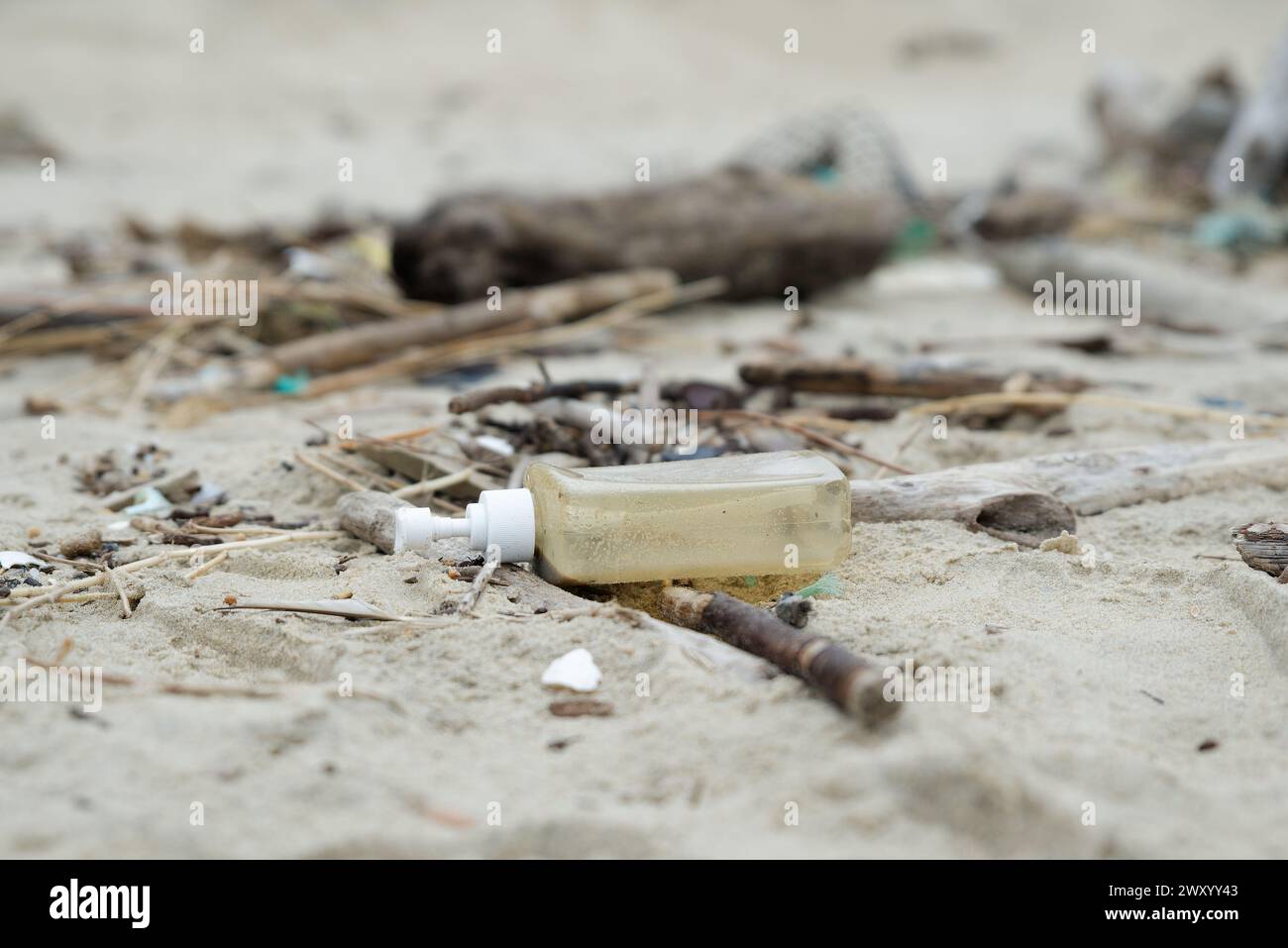 Plastic waste and various objects on the sand by the beach. Trash on ...