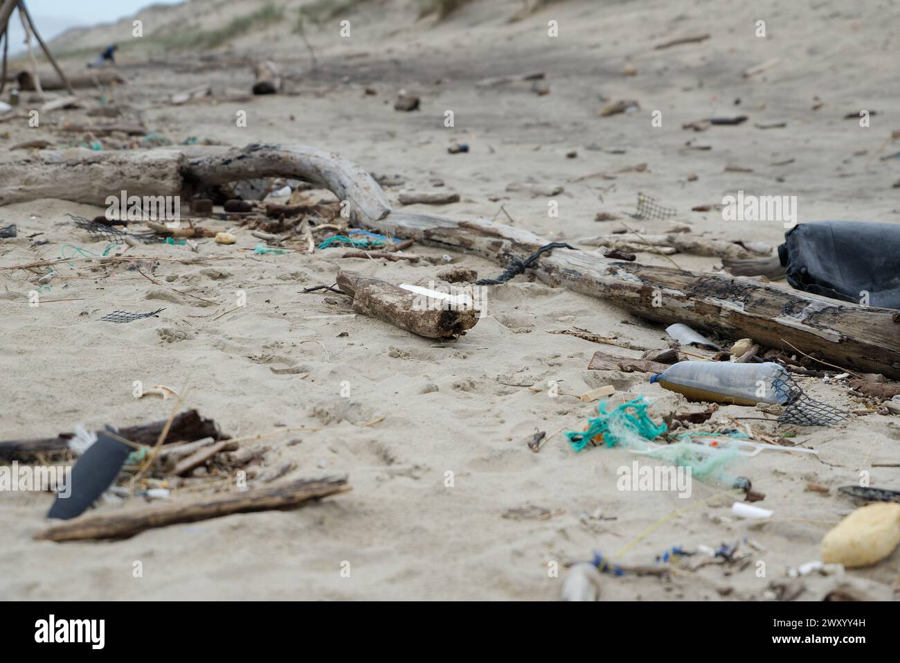 Plastic waste and various objects on the sand by the beach. Trash on ...