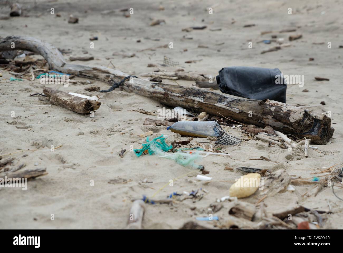 Plastic waste and various objects on the sand by the beach. Trash on ...