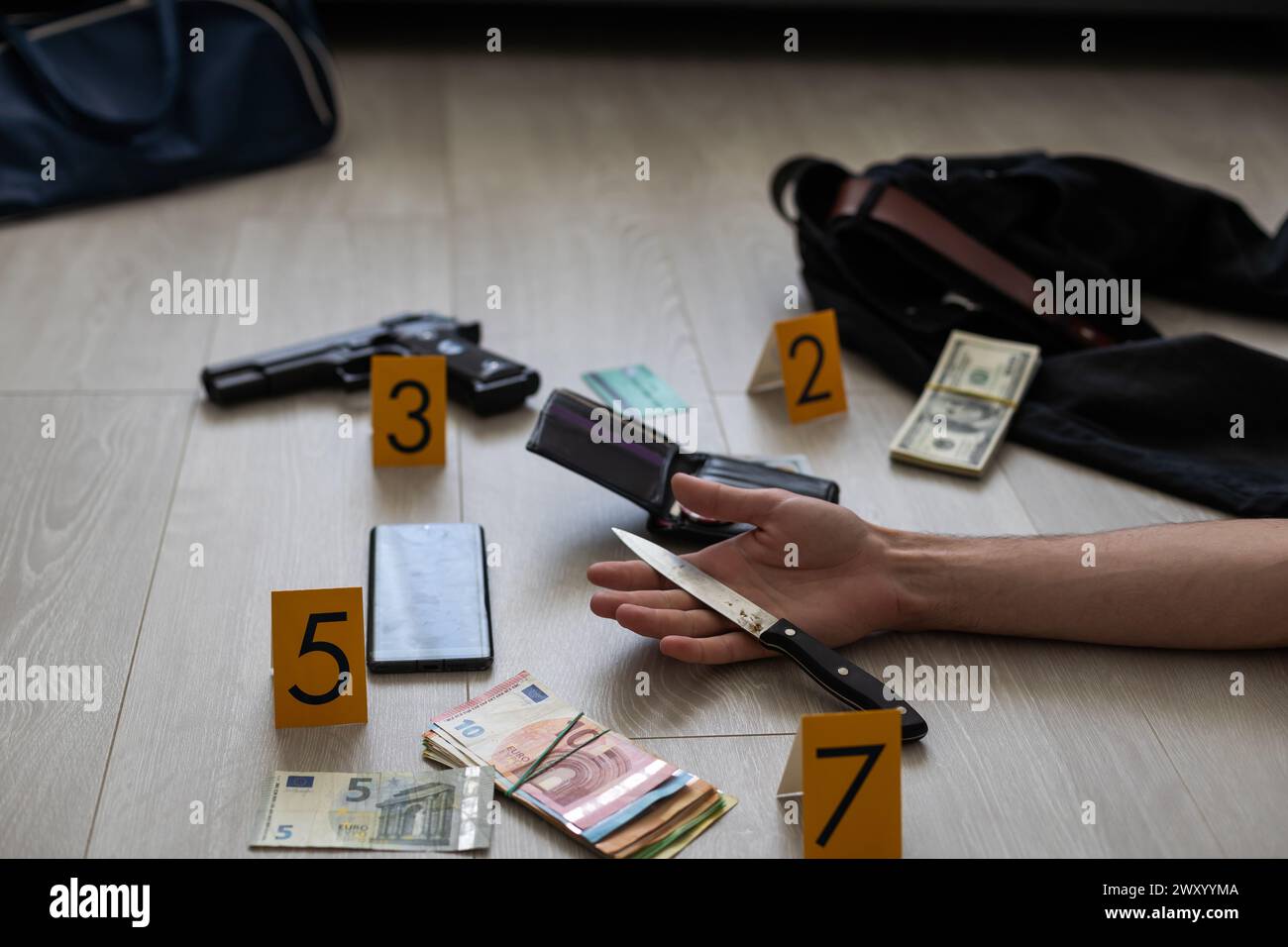 Hand of dead victim surrounded by evidence markers and objects on floor ...