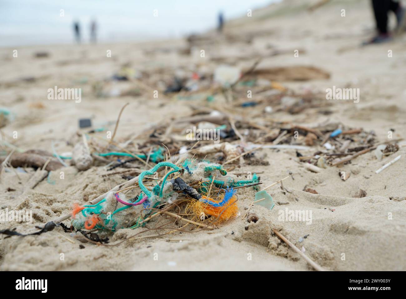 Plastic waste and various objects on the sand by the beach. Trash on ...