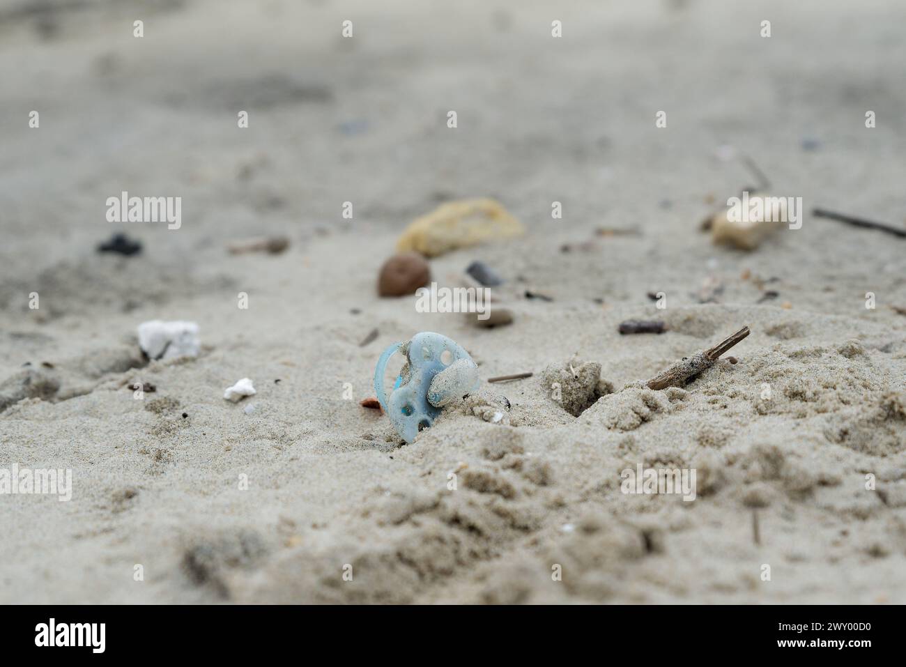 Plastic waste and various objects on the sand by the beach. Trash on ...