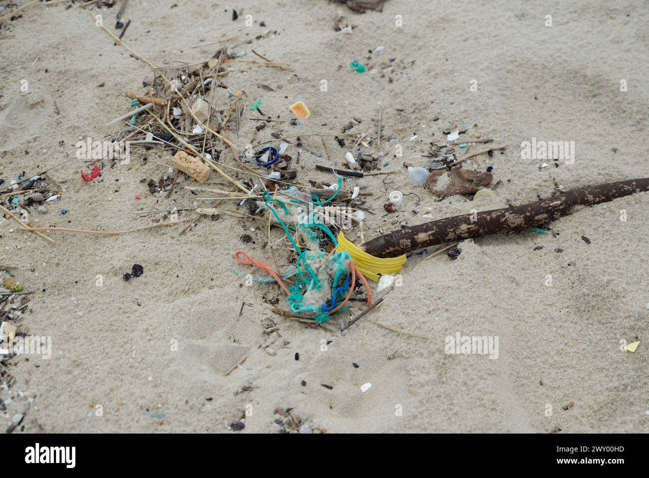 Plastic waste and various objects on the sand by the beach. Trash on ...