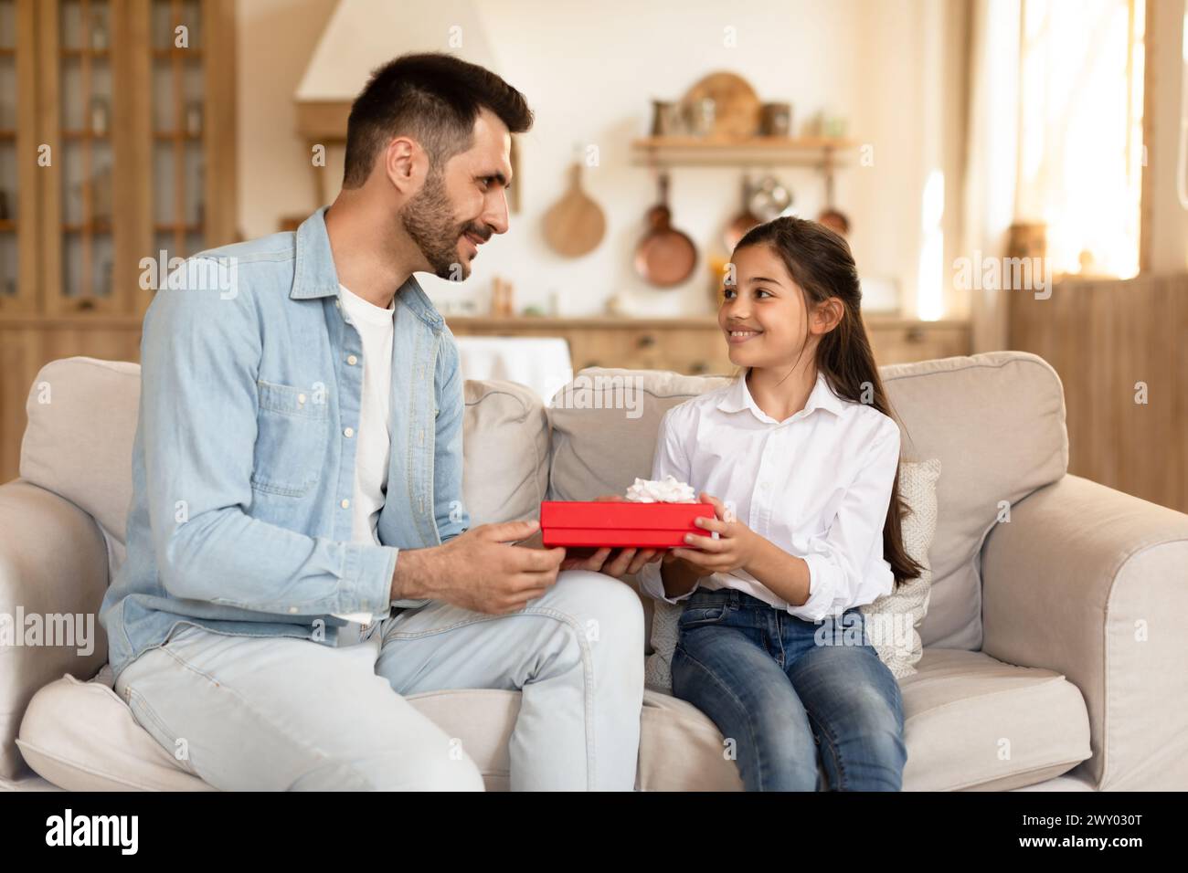 Father giving daughter a gift box at home Stock Photo - Alamy